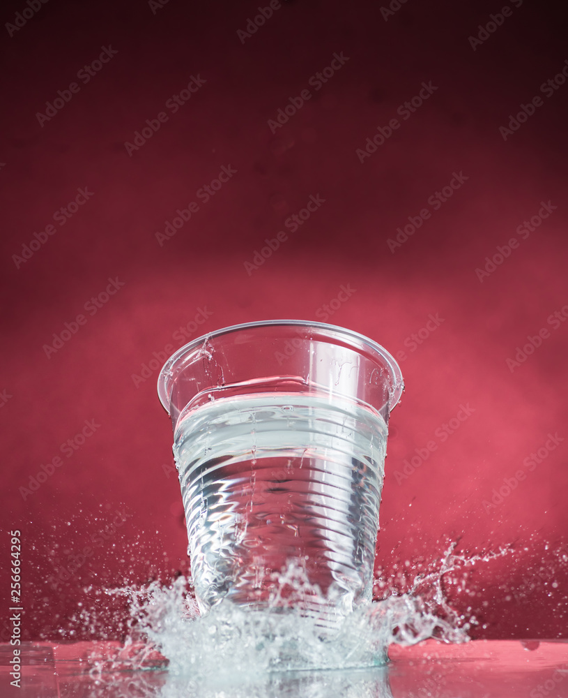 falling one-time transparent glass with clear water and spill water on ...