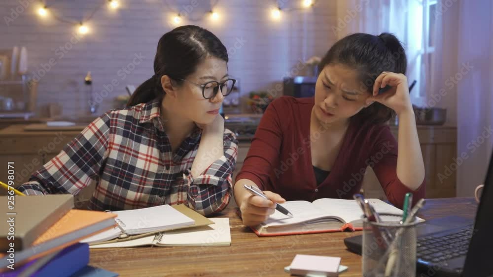 young attractive and bored asian woman doing homework prepare for test ...