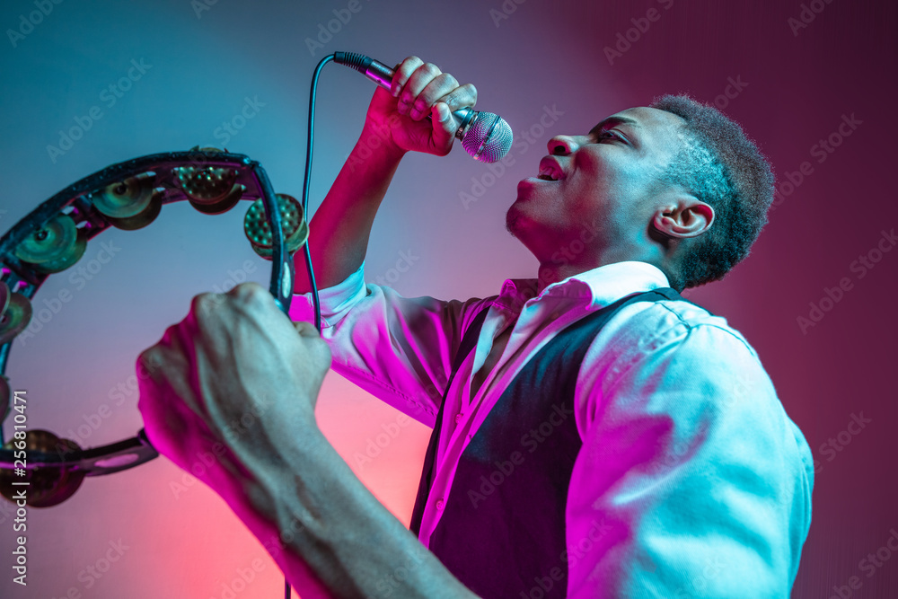 African American handsome jazz musician playing tambourine and singing ...