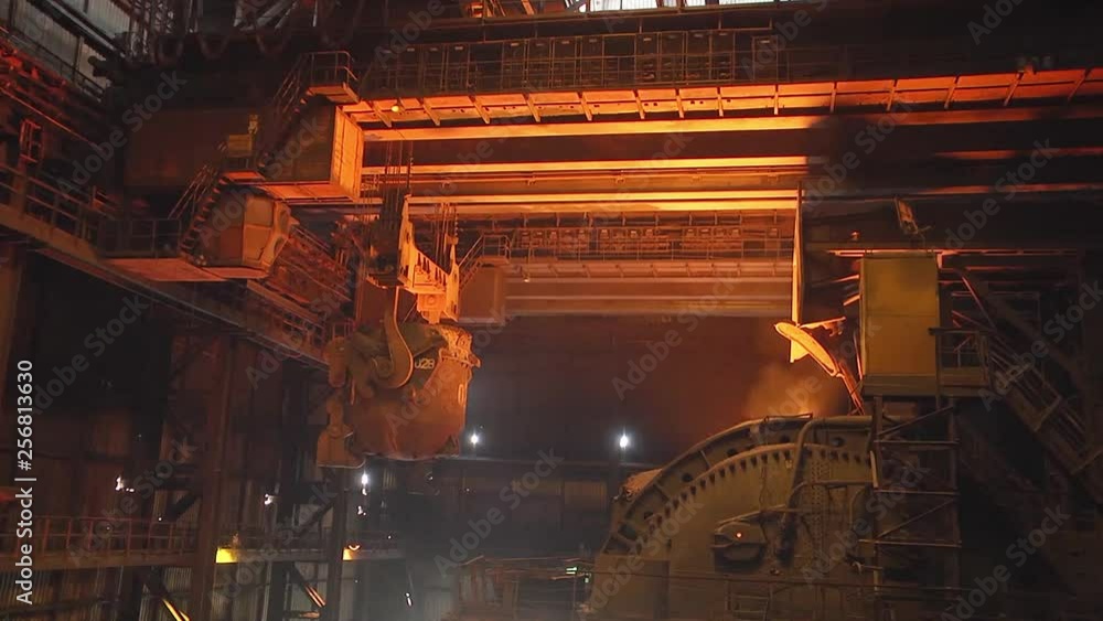 The process of pouring iron into the converter. Steel production at a ...