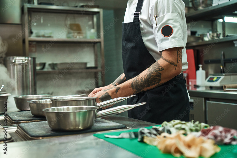 I love Italian food Side view of young chef's hands with tattoos ...