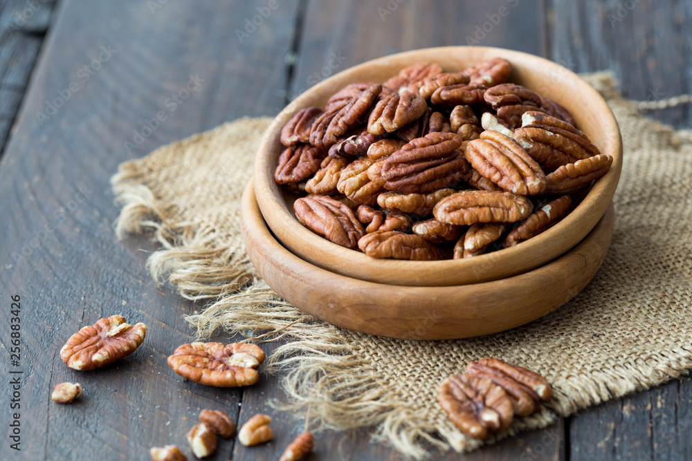 Pecan nuts on a rustic wooden table and pecan nuts in bowl. Stock Photo ...