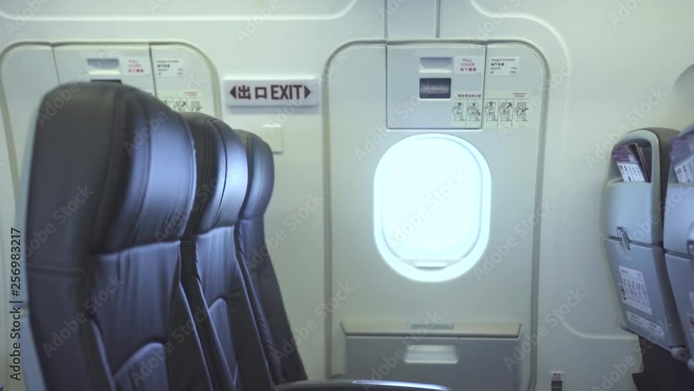 Passenger seats and emergency exit door inside commercial airplane ...