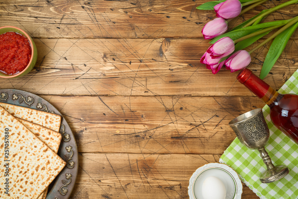 Jewish holiday Passover background with matzo, seder plate, wine and tulip flowers on wooden ...