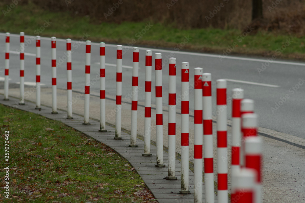 line of red white mark posts on a street in curve Stock Photo | Adobe Stock