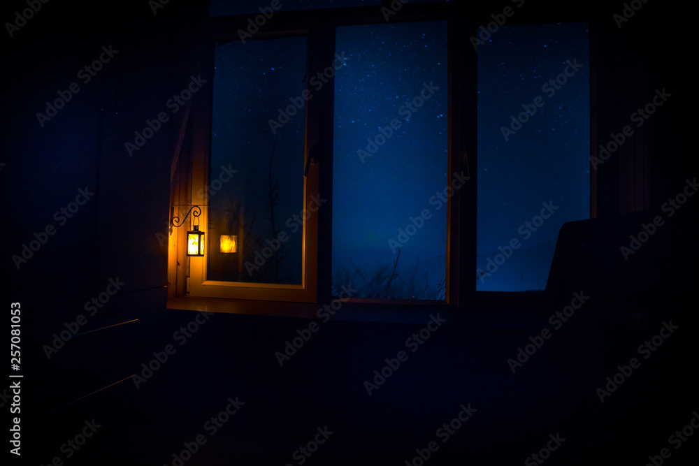 Night scene of stars seen through the window from dark room. Night sky ...