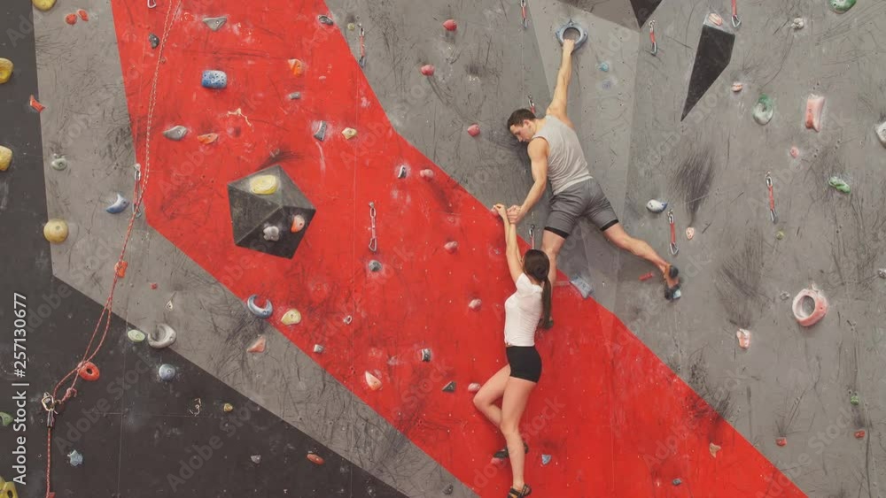 Fragile-looking girl hanging on muscular hand. Dangerous situation ...