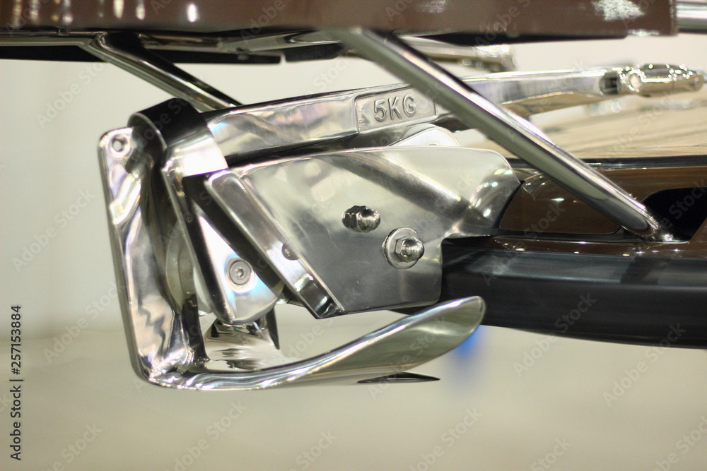 Shiny stainless steel 5 kg anchor and roll on forepeak of a motor boat ...