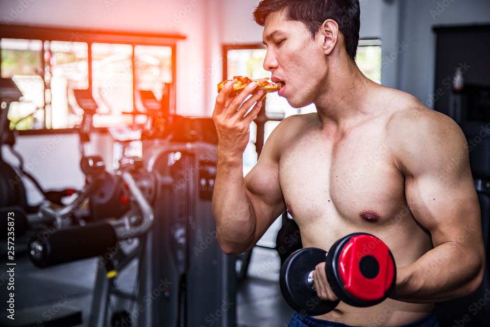 Strong muscular athlete men with pizza fast food. Unhealthy eating diet ...