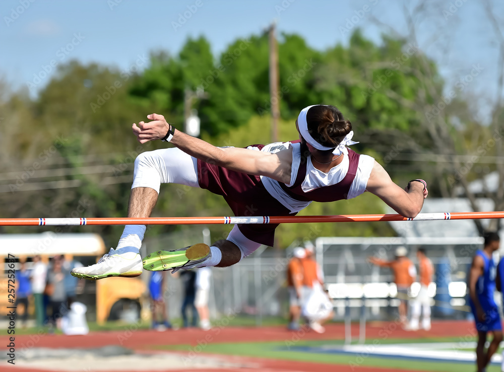 Young high school boy competing in the high jump at a track meet Stock ...
