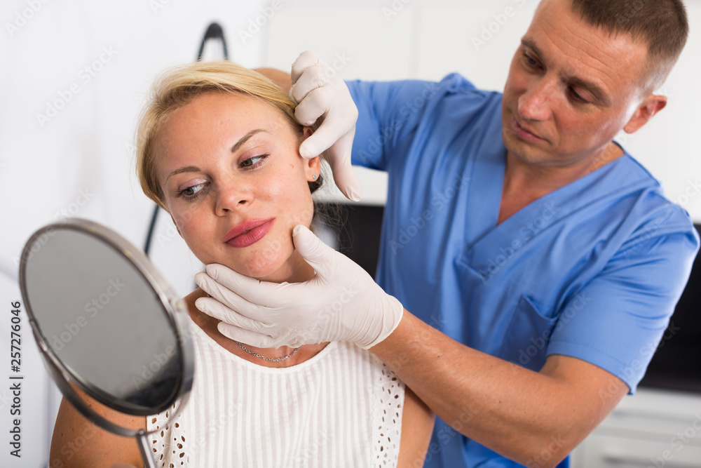 Doctor is examining woman patient behind mirror before the procedure ...