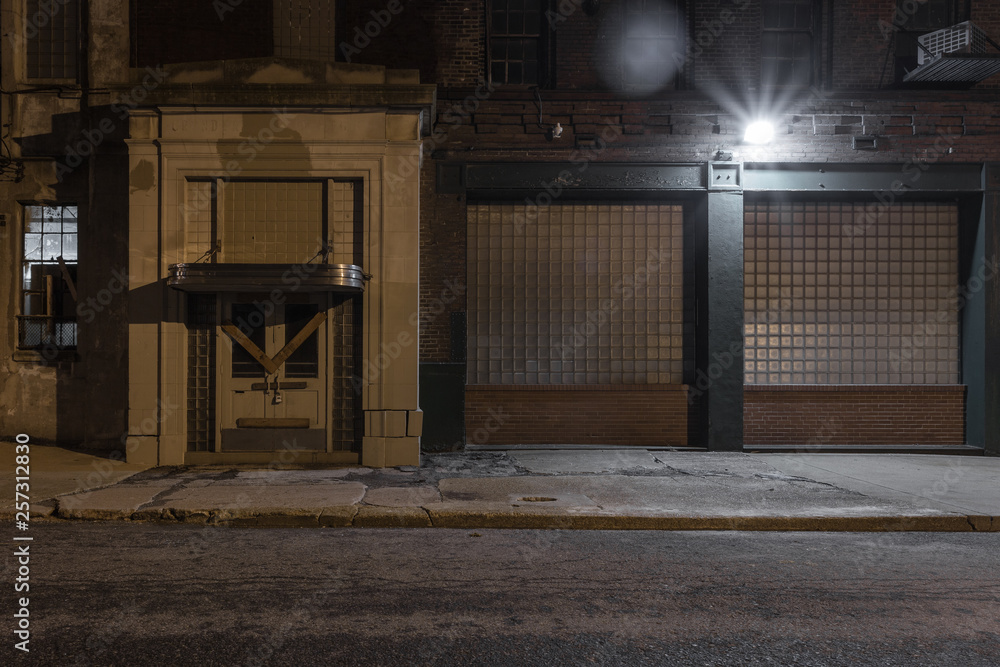 Boarded up entrance to an abandoned factory with classic architectural ...