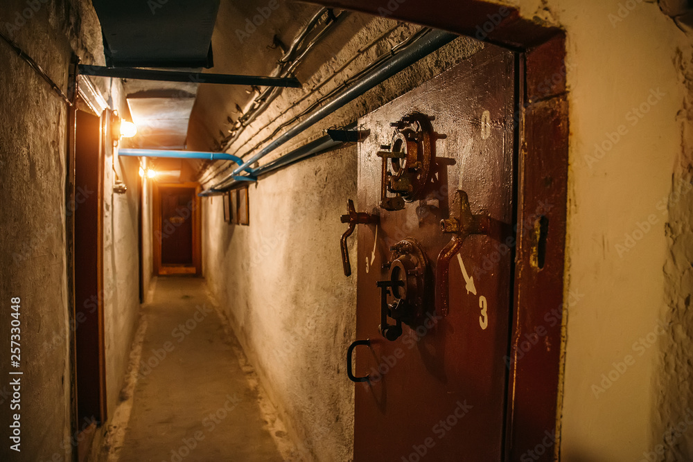 Long corridor or illuminated tunnel in bomb shelter with large steel ...
