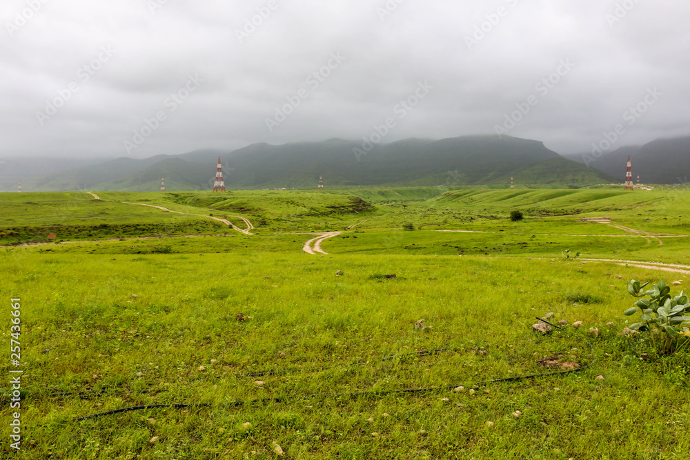 Lush green landscape, trees and foggy mountains in Ayn Khor tourist ...