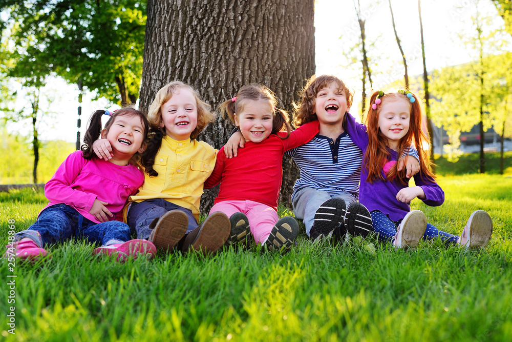 a group of small children in colorful clothes embracing sitting on the ...
