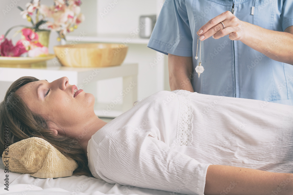 Therapist using pendulum to make a diagnosis Stock Photo | Adobe Stock
