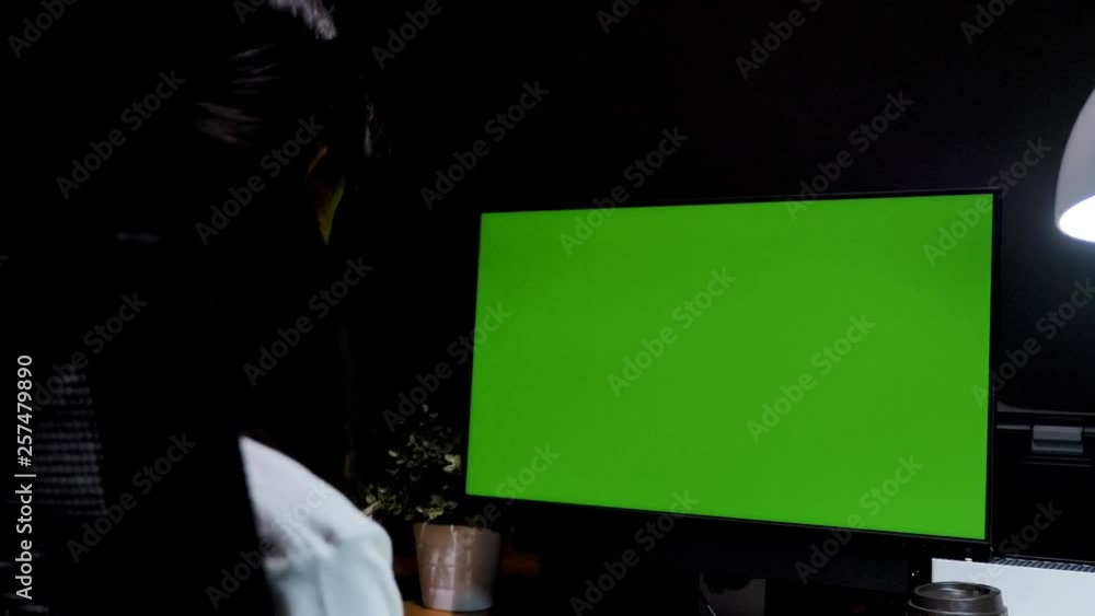 Zoom in shot Asian girl sitting at her desk with Chroma key green ...