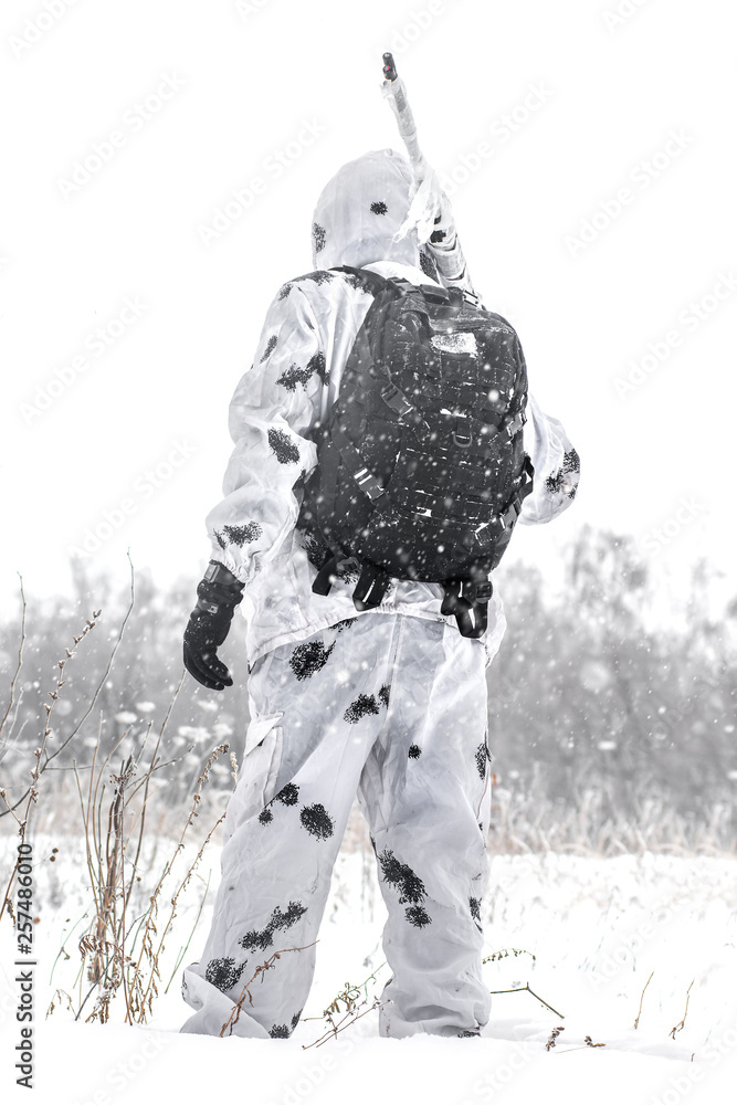 Man soldier in the winter on a hunt with a sniper rifle in white winter ...