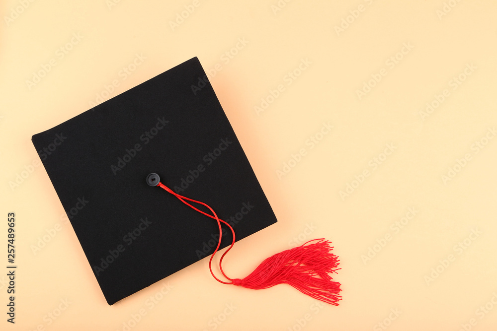 Graduation cap on beige background Stock Photo | Adobe Stock