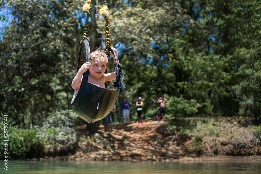 Boy riding zip line over water, Rancho Santa Elena, Hidalgo, Mexico ...