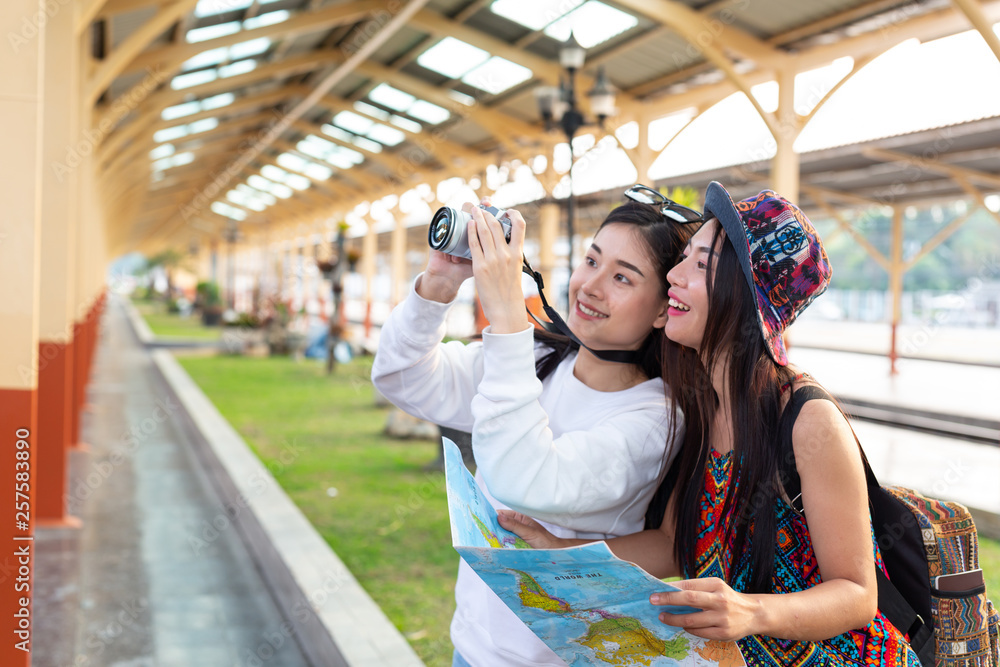 Two women are holding the map while waiting for the train. Tourism ...