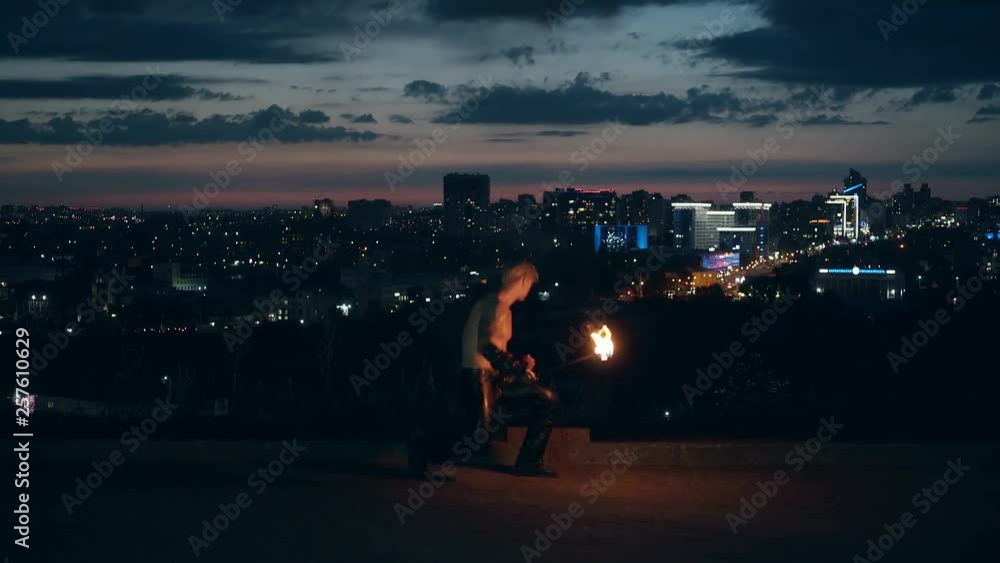 Young blond male does tricks with fire, breaths fire in the middle of ...