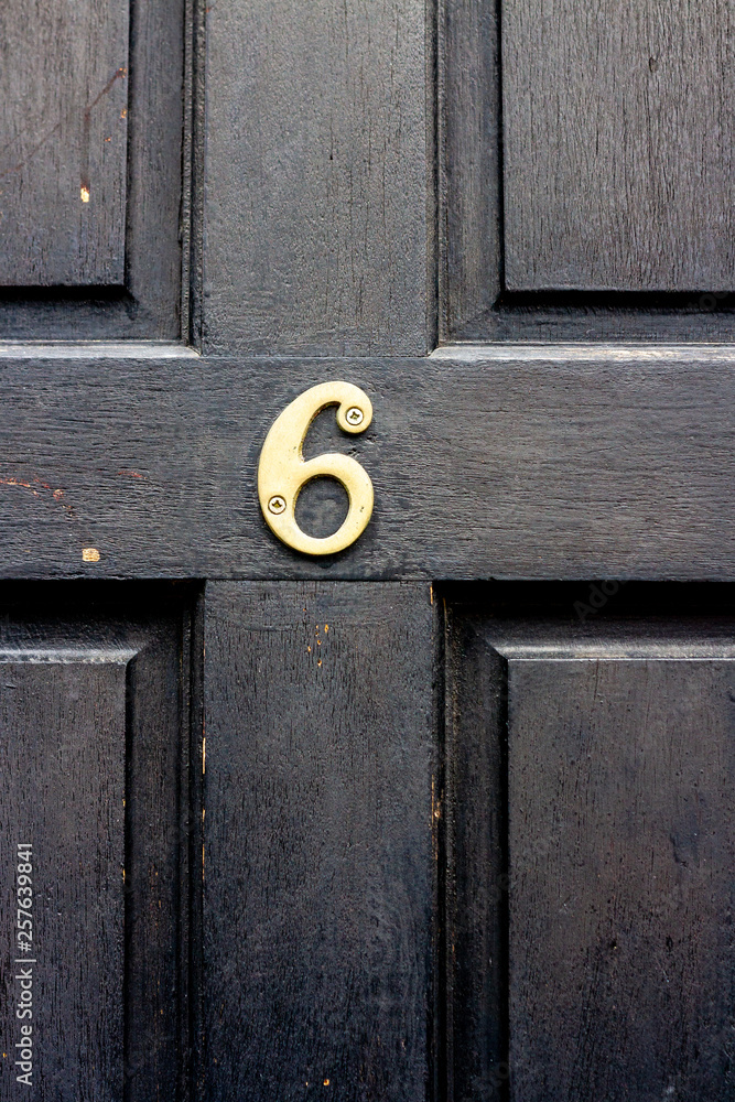 House number six seen with the 6 in bronze on the black crossbar of a ...