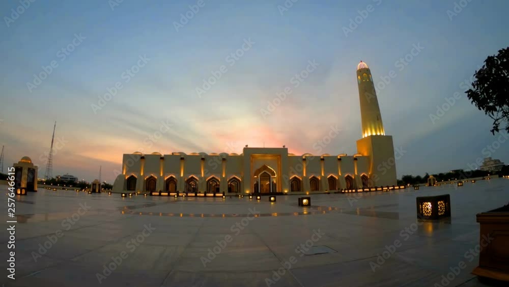 Wide view of Doha Grand Mosque illuminated, mirroring on outdoor marble ...