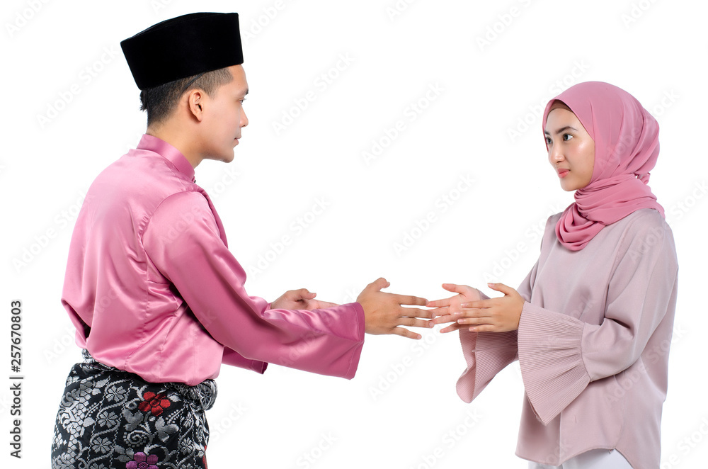 Portrait of young man with traditional clothing shaking hand his wife ...