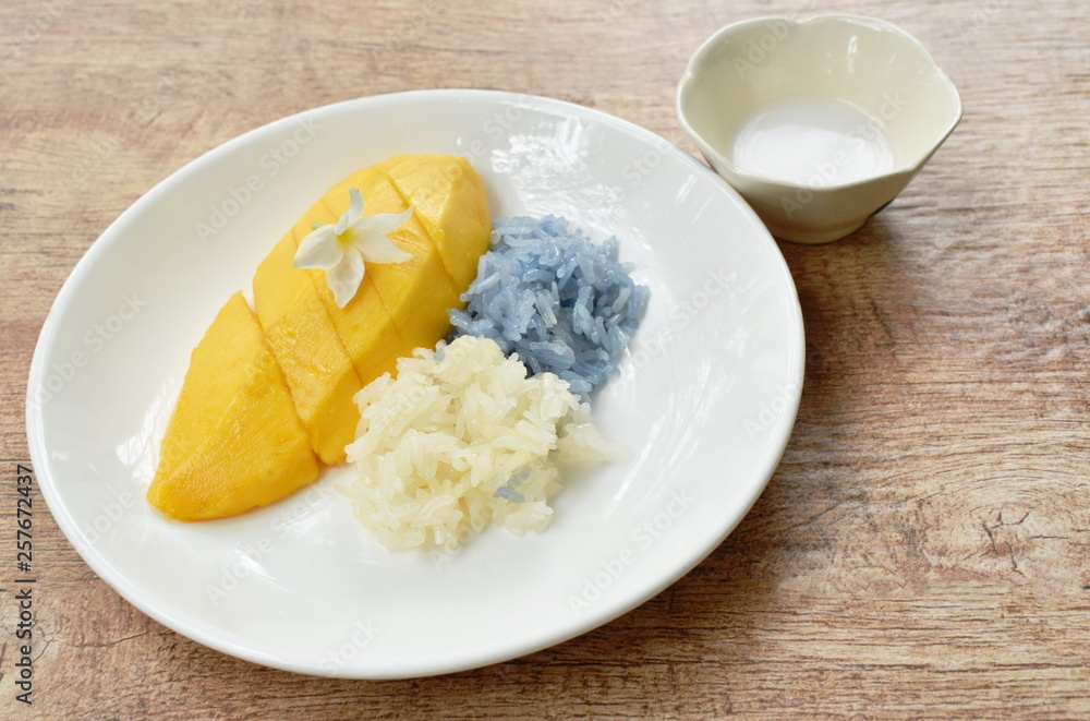 ripen mango with white and purple sticky rice dressing coconut milk on ...