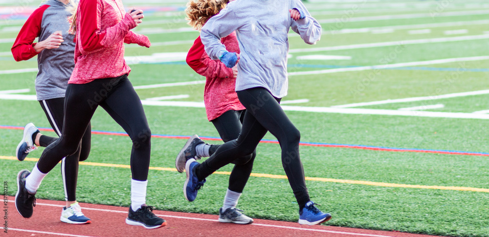 Four high school girls running on a track Stock Photo | Adobe Stock