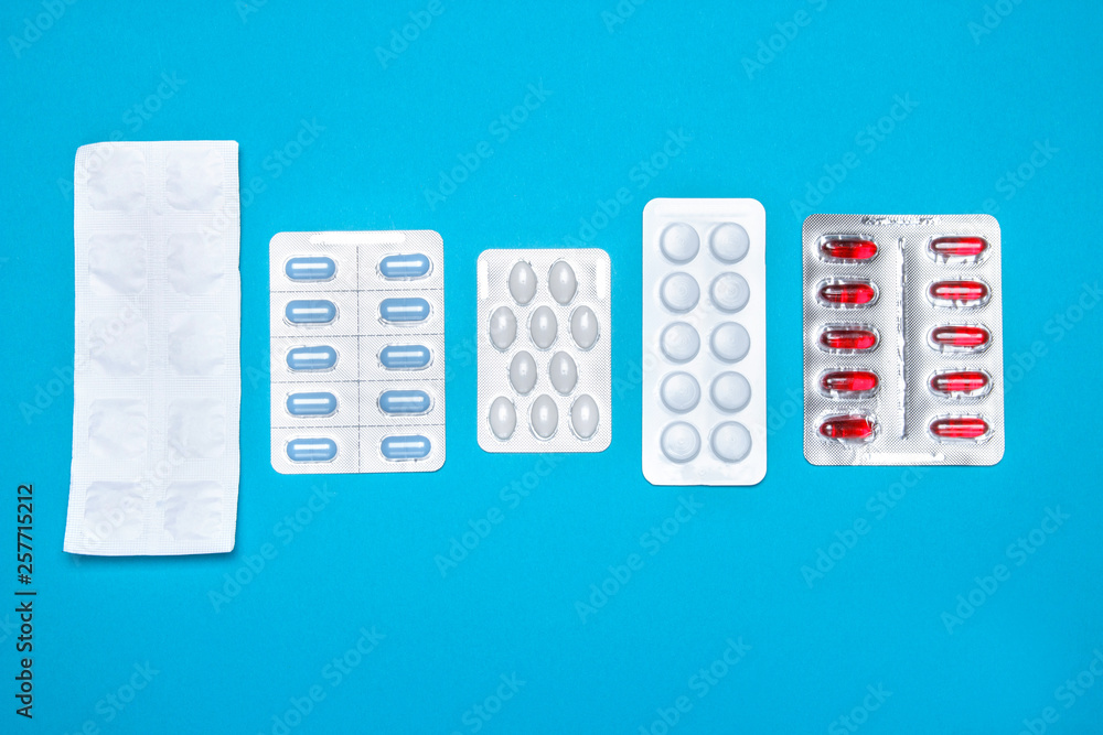Capsule pills in a blister pack, on a blue isolated background. The ...
