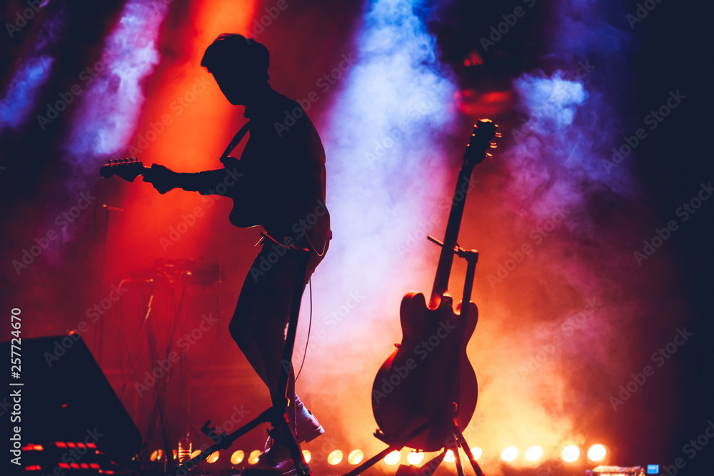 Guitarist on a stage playing rock to the crowd of people. Musician ...