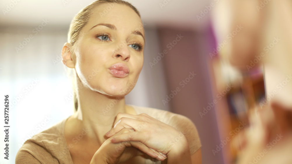 the girl looks in the mirror, dissatisfied with the appearance, pulls ...