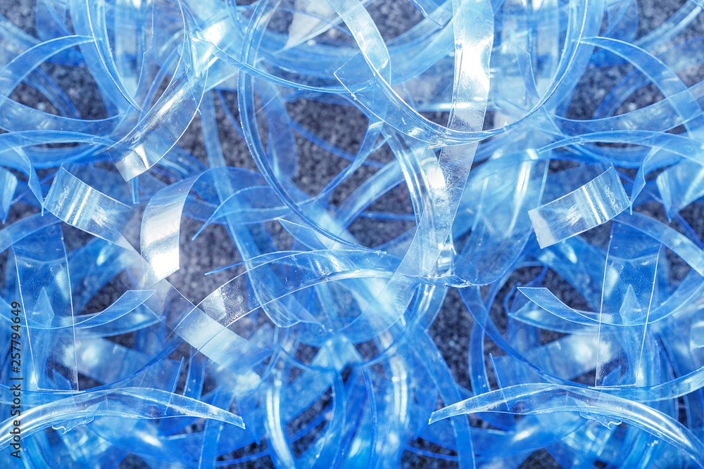 Small pieces of cut blue plastic bottles. background of the pieces of ...
