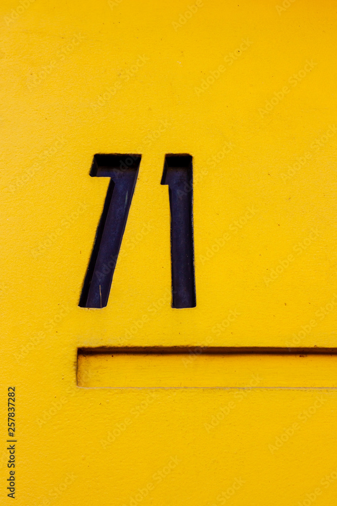 House number seventy-one with the 71 in thick black lines on a bright ...