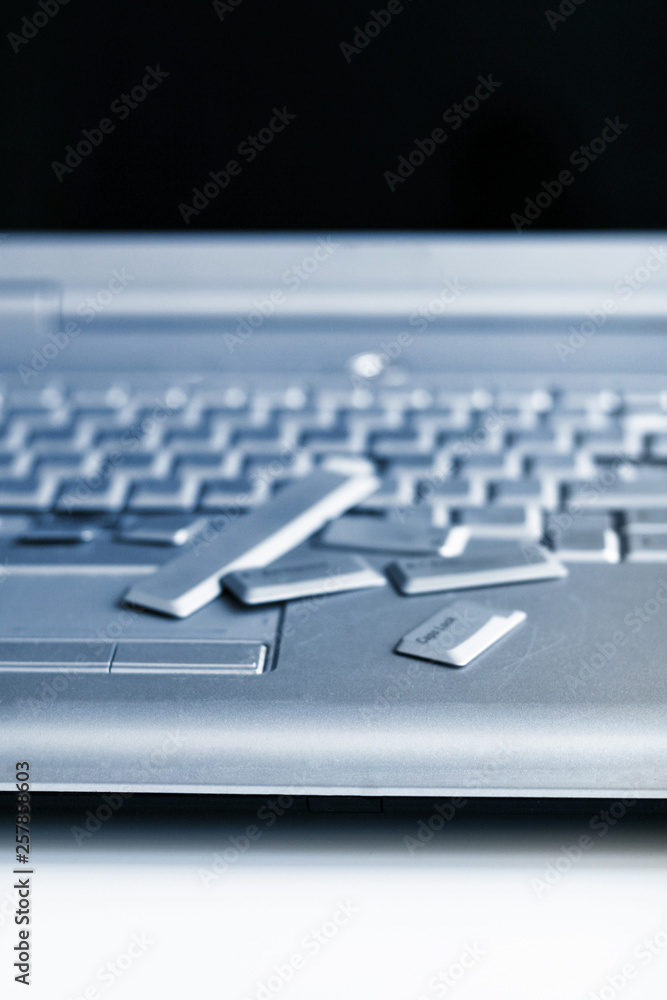Silver laptop with broken keyboard. A close-up picture of part of ...