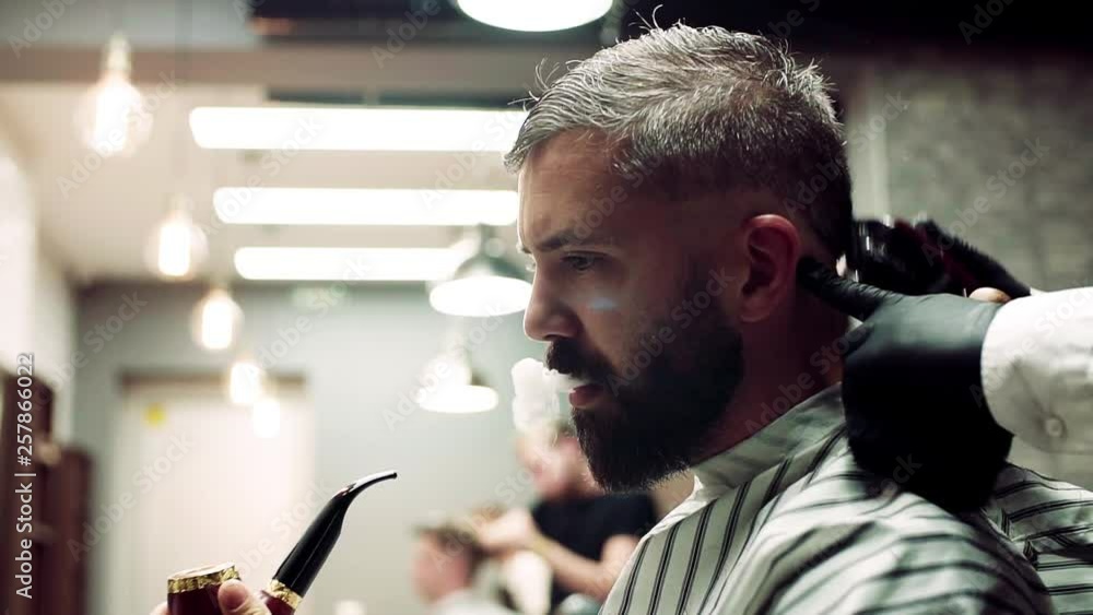 Hipster man client visiting haidresser and hairstylist in barber shop ...