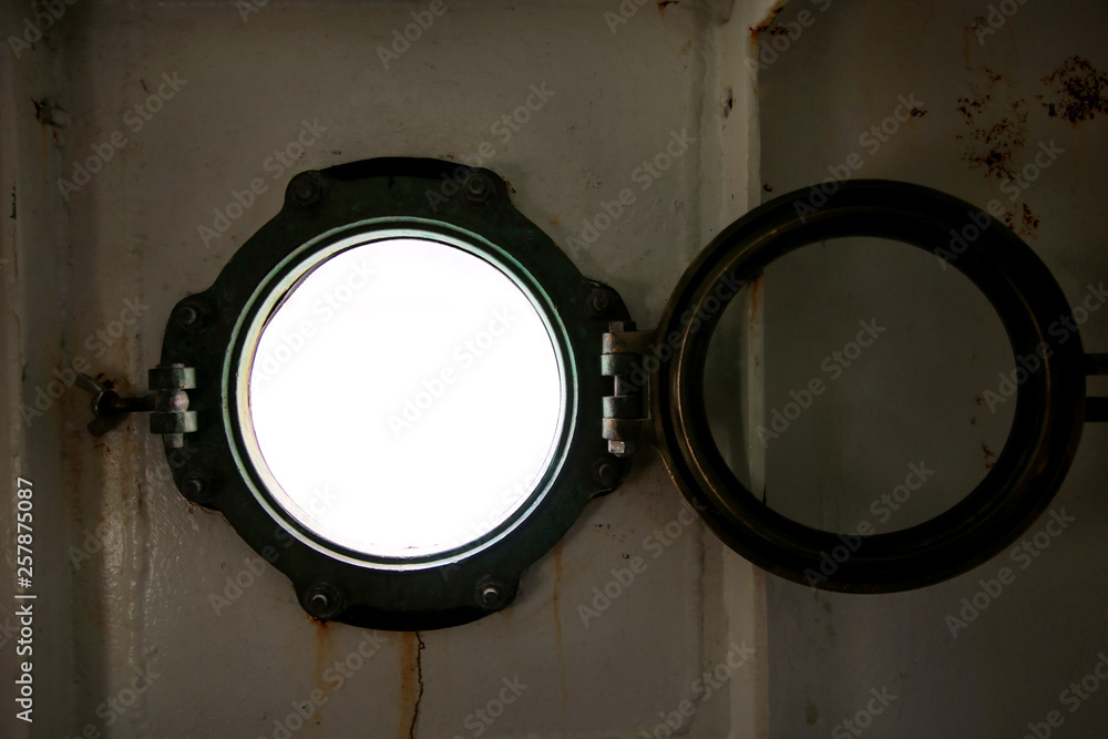 Hinged round window, storm cover on ship looking outside into ...