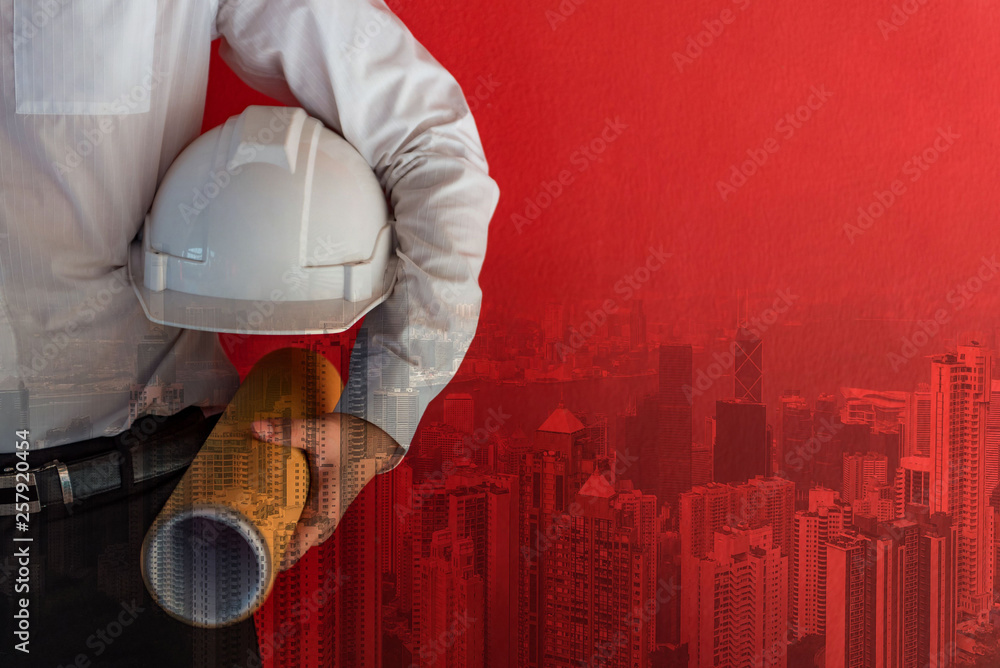 Double exposure of male civil engineer holding protective safety helmet ...