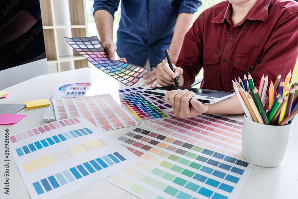 Two colleague creative graphic designer working on color selection and ...