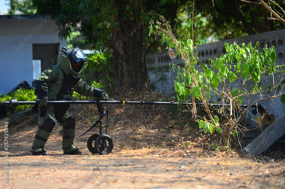 EOD officer in The explosive ordnance disposal suit using remote robot ...