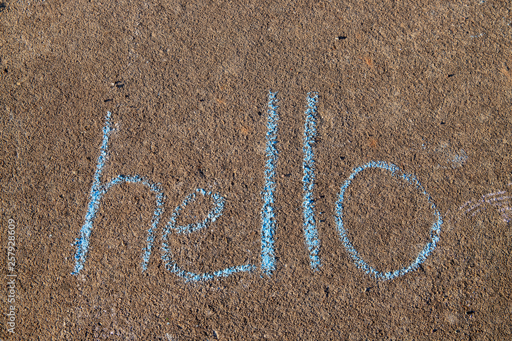 the word Hello written with sidewalk chalk on gray concrete pavement ...