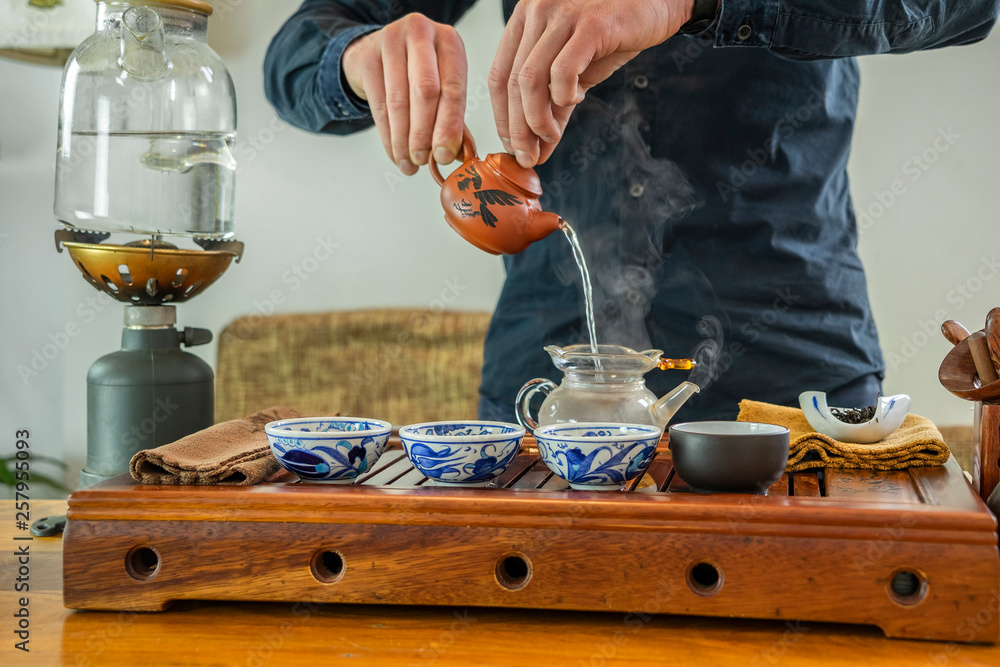 Chinese tea tasting in the tea shop. Tea seller, dressed in European ...