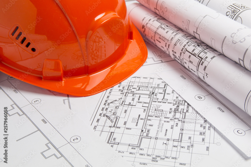 Paper architectural drawings, blueprint and helmet. Engineering ...