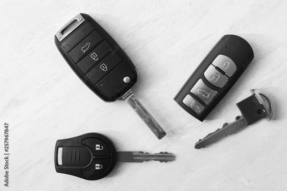 Flat lay composition with different car keys on light background, top ...