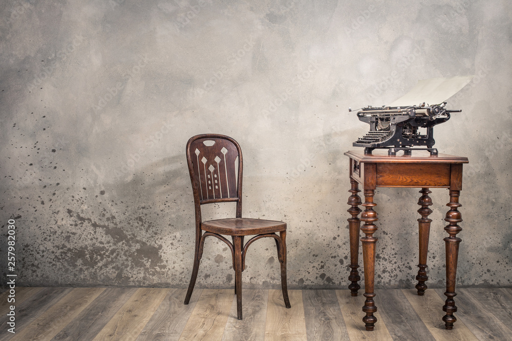Vintage loft room with old typewriter on wooden table and antique chair ...