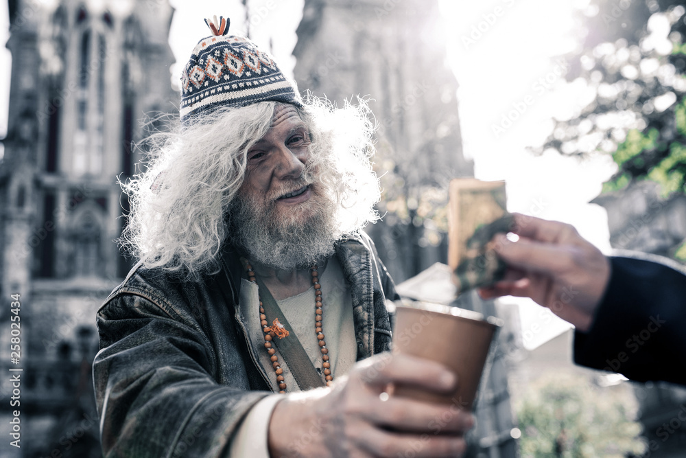 Dirty long-haired homeless wearing funky clothes and asking for money ...