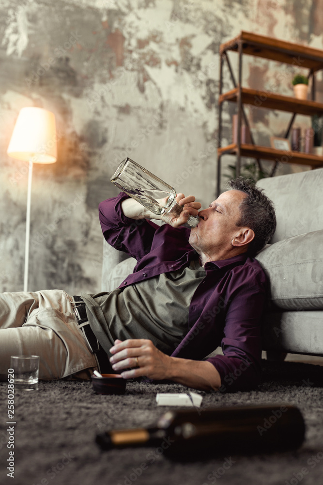 Resolute old man drinking vodka directly from bottle Stock Photo ...
