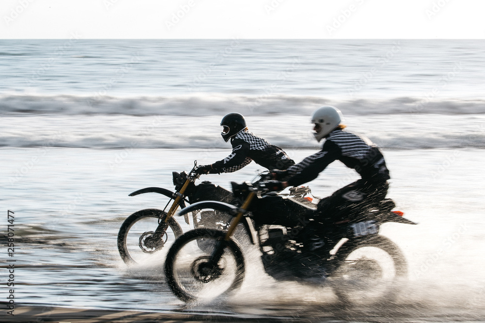 Two friends racing on custom retro style cafe racer black motorcycles ...